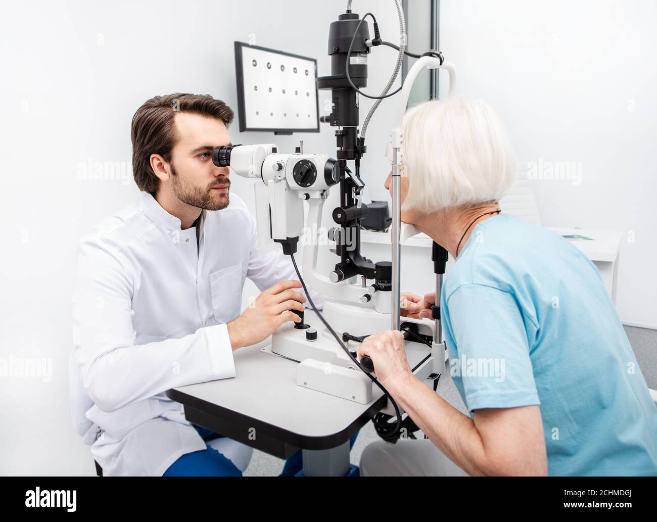 Practicing ophthalmologist examines a senior woman patient's with ...