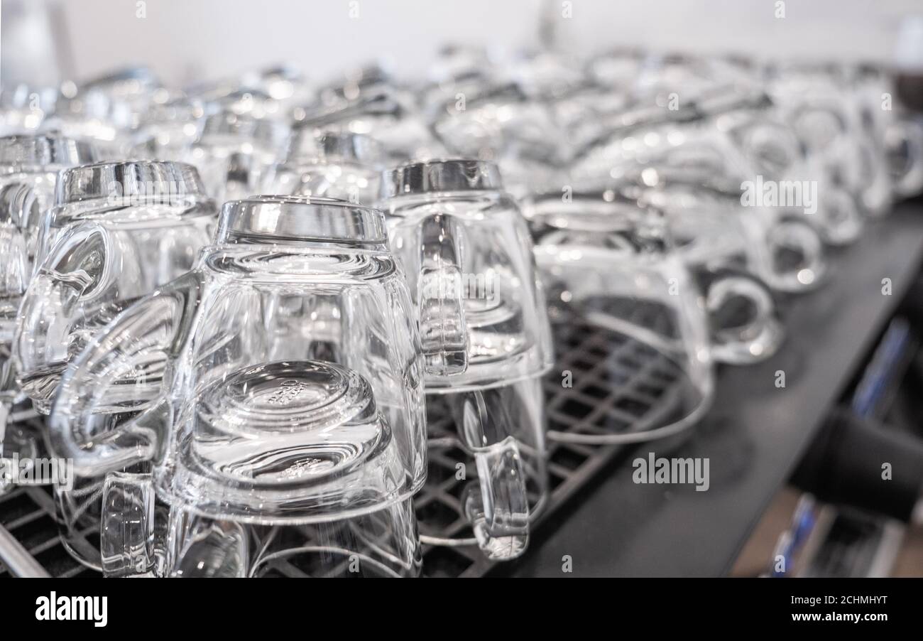 Clear glass coffee cups stacked on the heating area of a commercial ...