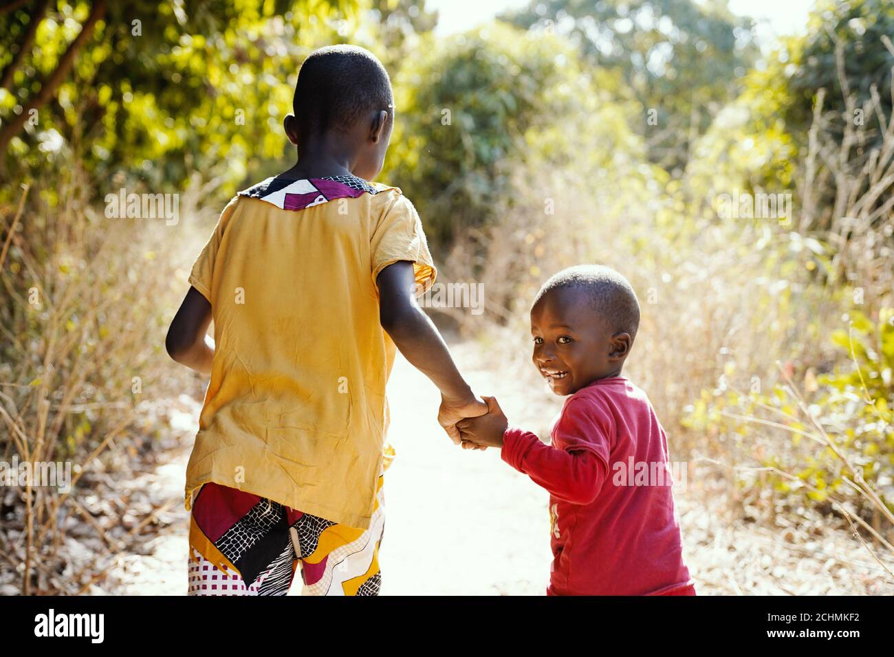 Smiling African Children Walking Outdoors in Typical Tribal Town Near ...