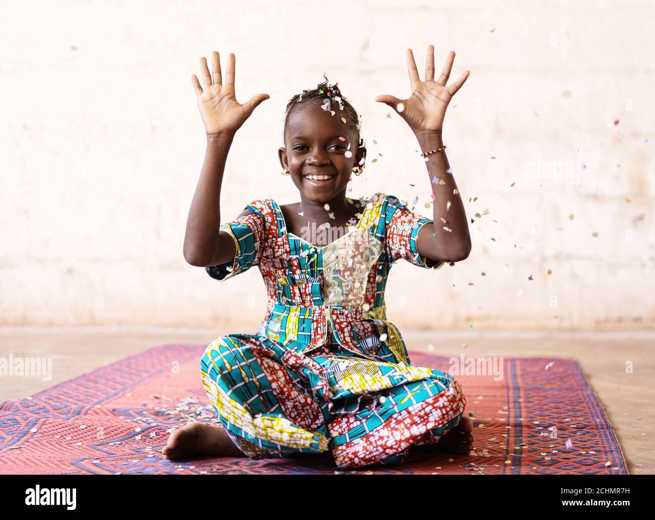 African Fun Party Girl, smiling woman throwing confetti, against a ...