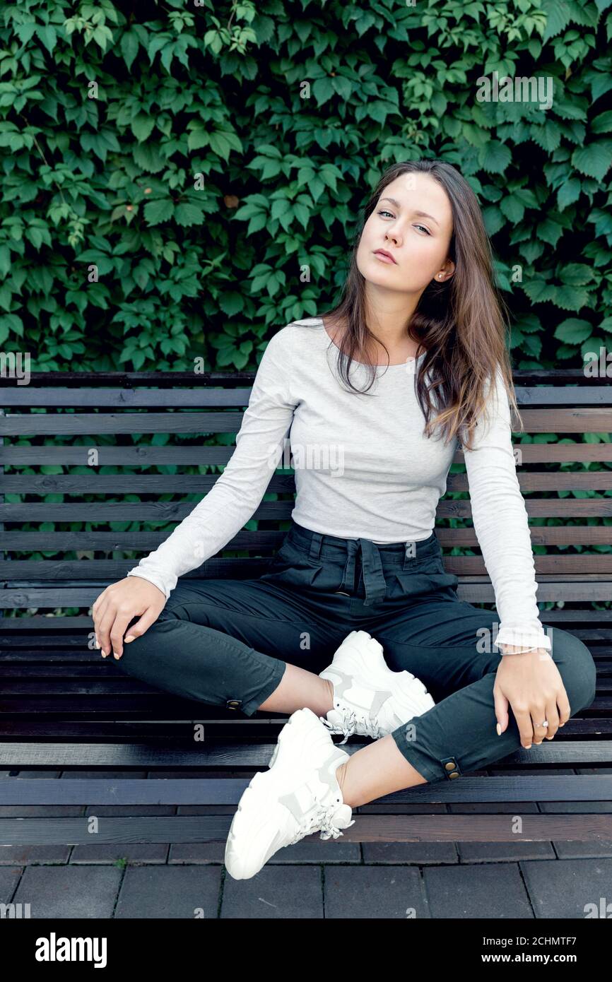 Beautiful girl sitting on a bench in the Park Stock Photo - Alamy
