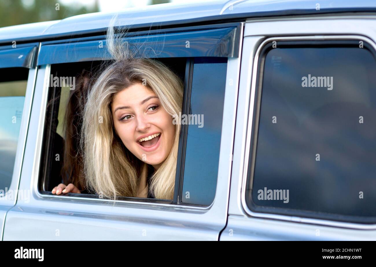 A blonde girl looks out of an open car window Stock Photo - Alamy