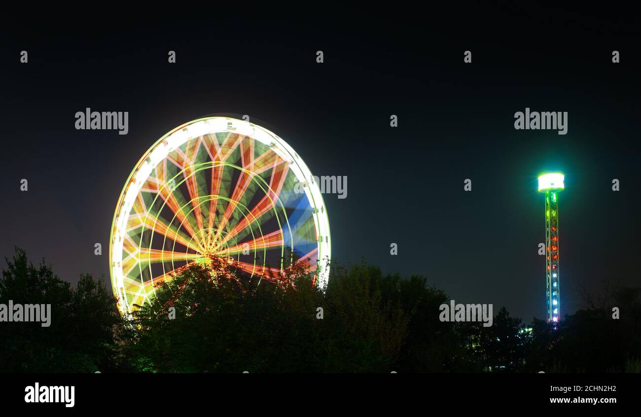 Ferris Wheel and Tower at night Stock Photo - Alamy