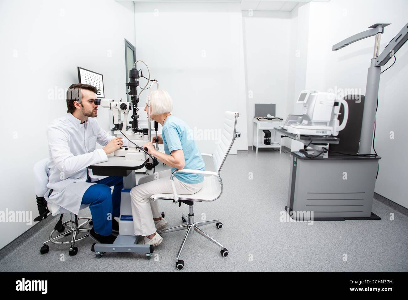 Optometrist and senior patient while vision diagnostic at a modern ...