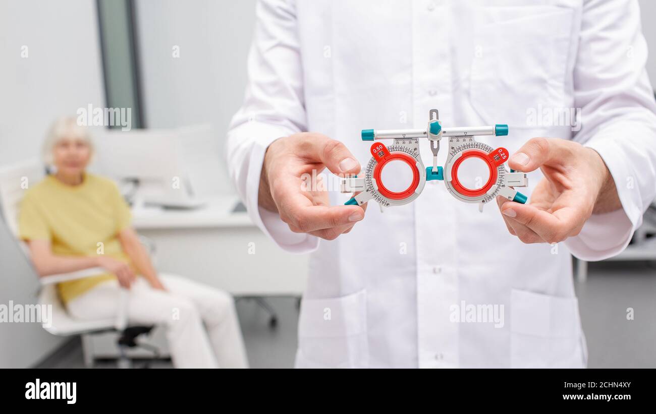 doctor holding an optometric trial frame for eye exam in his hands ...