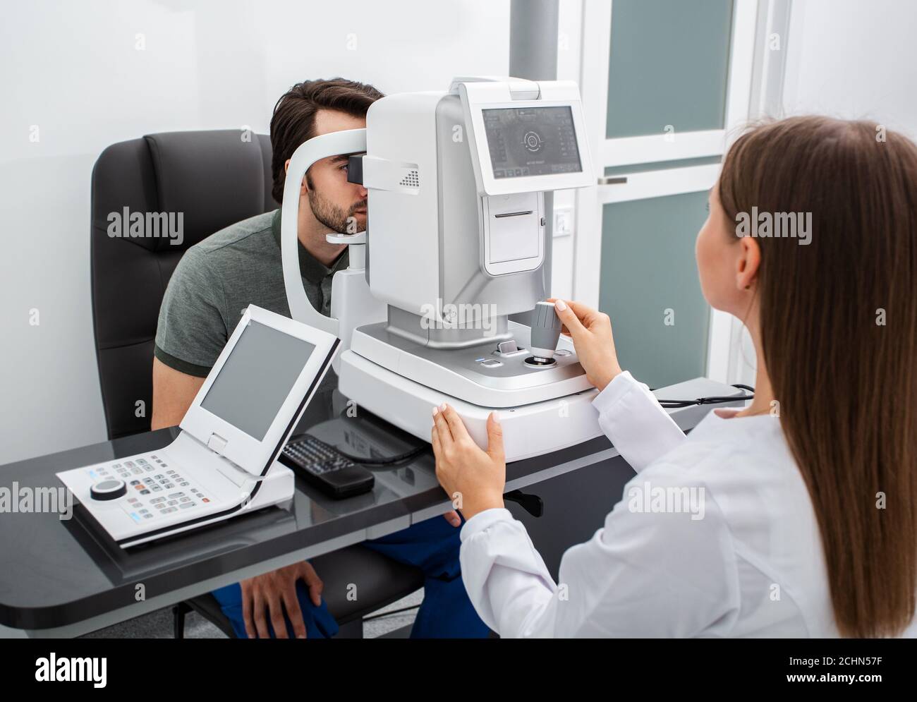Woman ophthalmologist using autorefractor calculate the vision ...