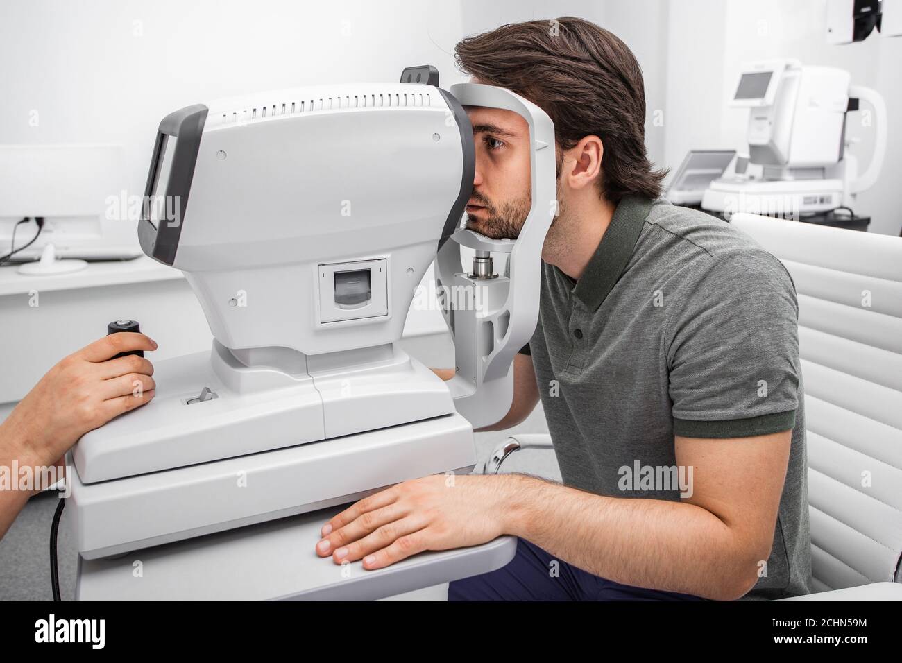 Handsome man checking eyesight in a clinic using diagnostic ophthalmic ...