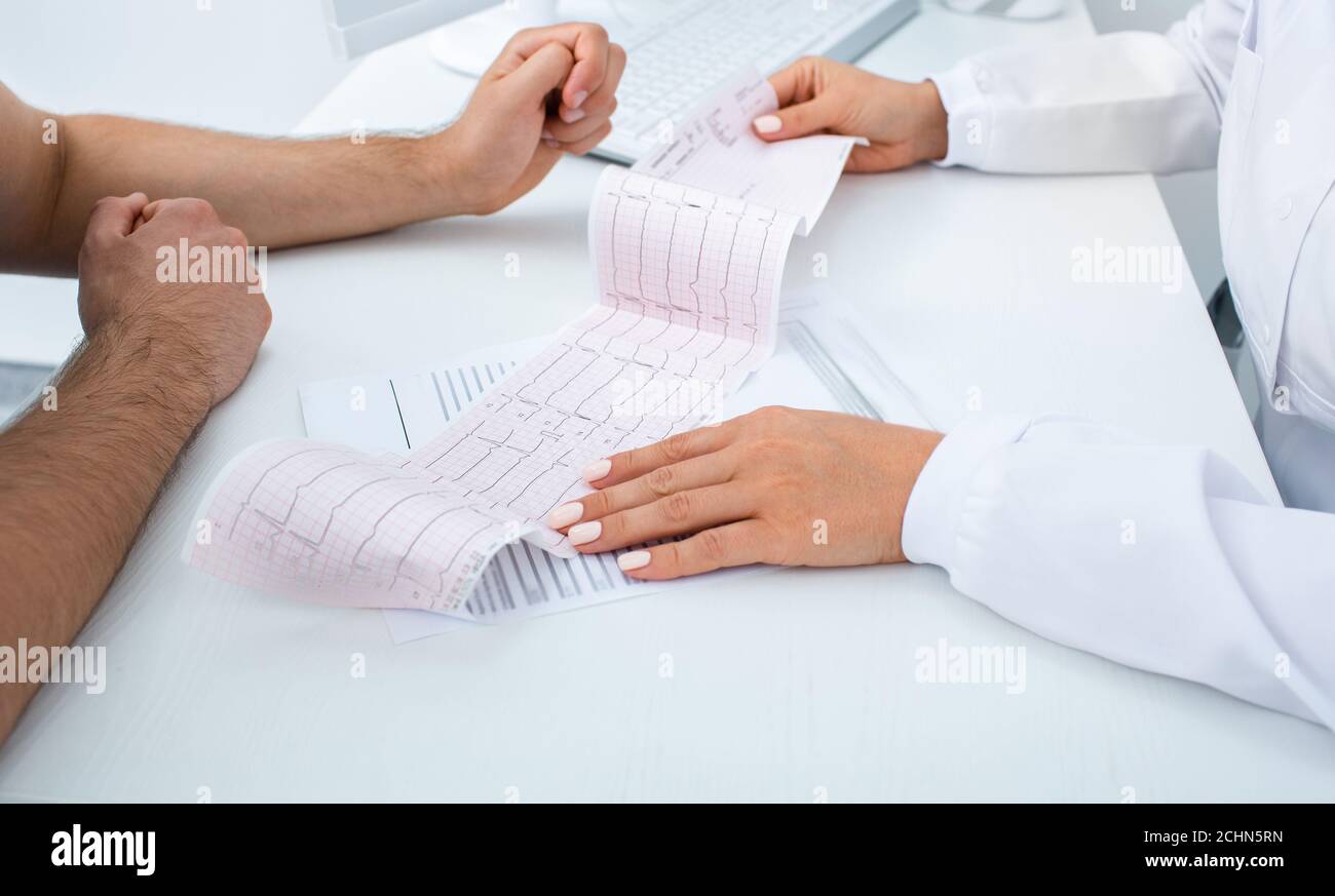 doctor analyzes the electrocardiogram results, close-up. Diagnosis of ...