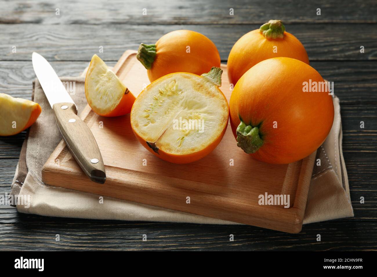 Board with zucchini, knife and towel on wooden background Stock Photo ...