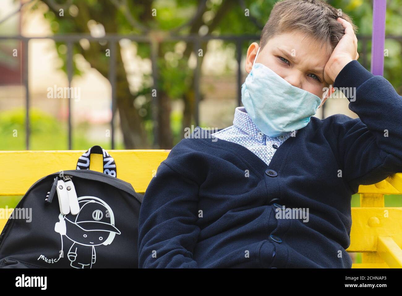 tired kid boy wearing a face mask for coronavirus prevention. Back to ...