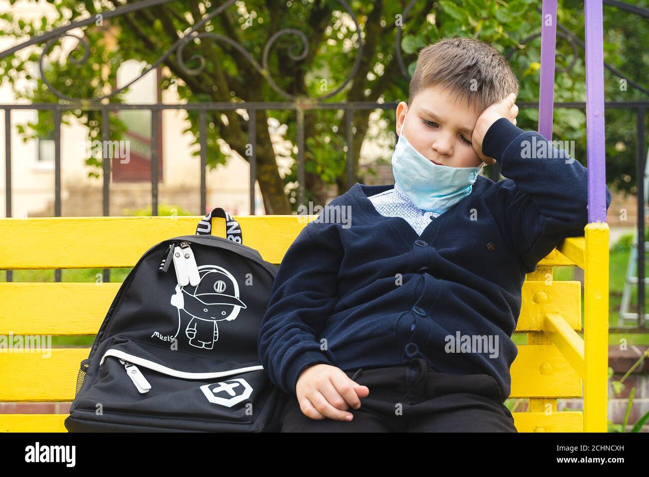 thoughtful kid in mask wants ending quarantine. sad school boy looking ...