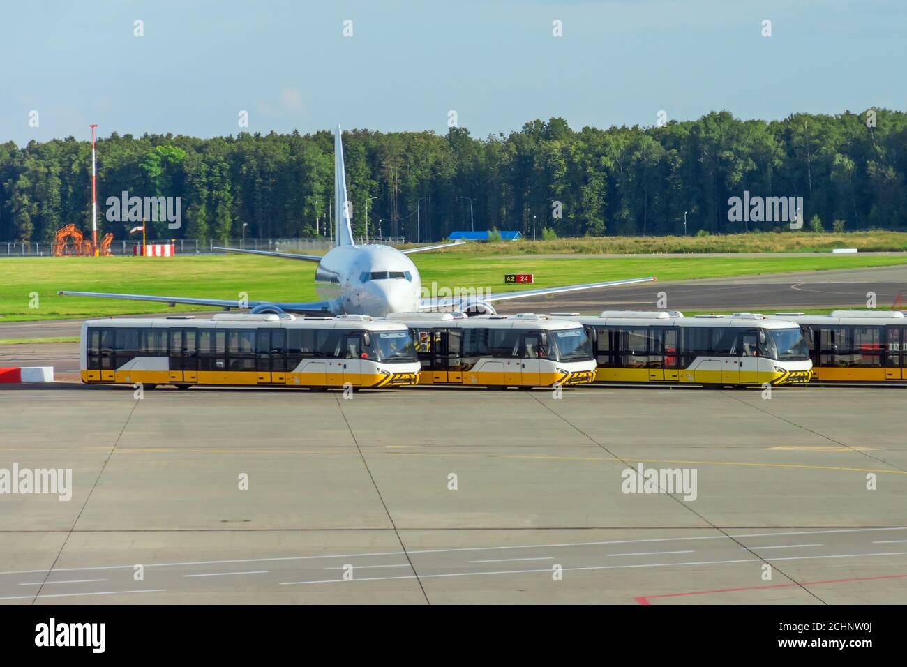 Three passenger buses in front of the plane on the apron at the airport ...
