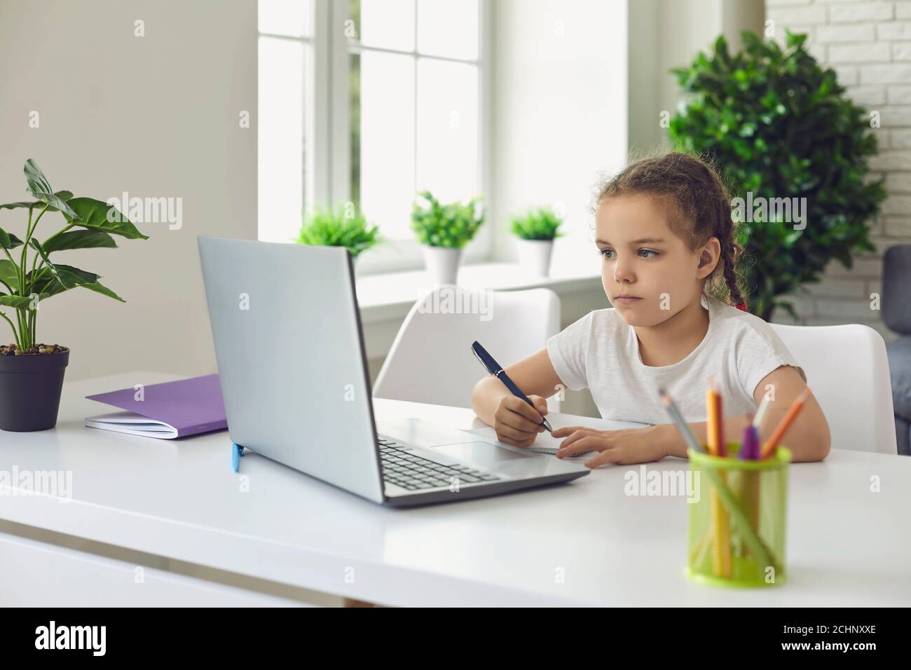 Online schooling. Little girl participating in video lesson on laptop ...