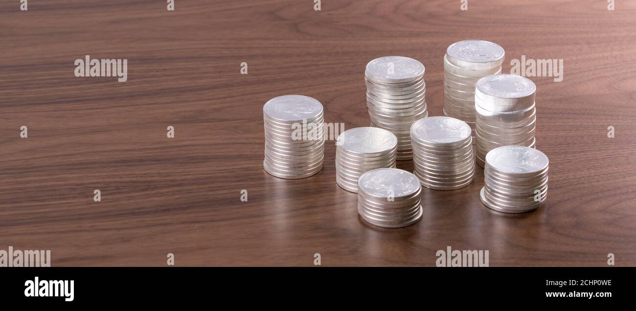 Stacks of Silver coins on a wood table top Stock Photo - Alamy