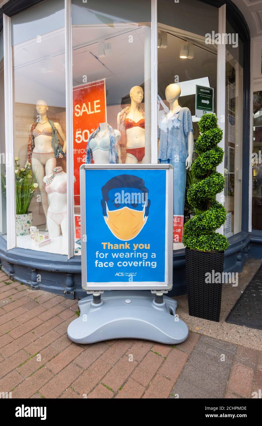 Roadside sign outside a shop entrance requesting that customers wear a ...