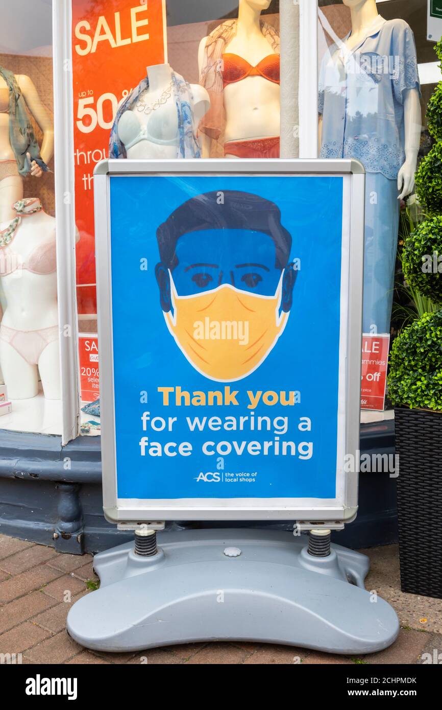 Roadside sign outside a shop entrance requesting that customers wear a ...