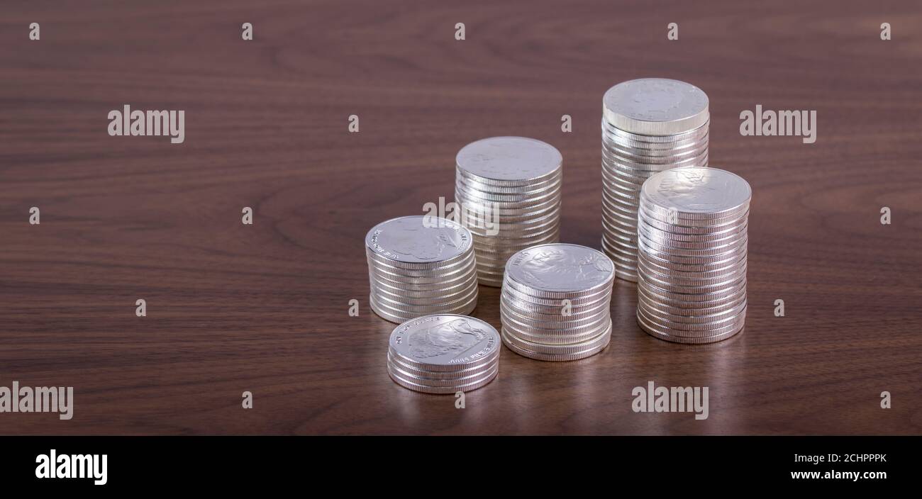 Stacks of Silver coins on a wood table top Stock Photo - Alamy
