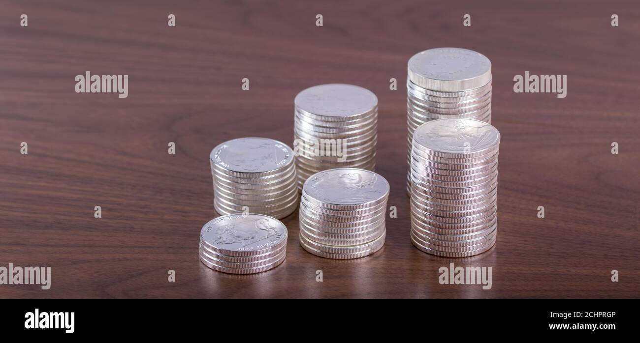 Stacks of Silver coins on a wood table top Stock Photo - Alamy