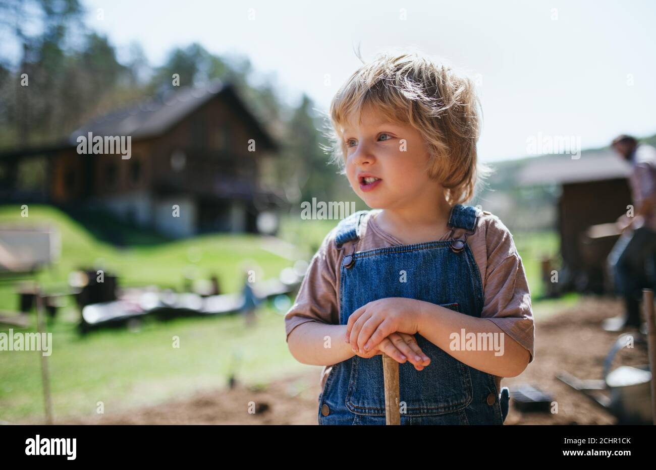 Small boy working outdoors in garden, sustainable lifestyle concept ...