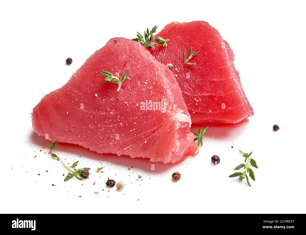 Two slice of raw tuna meat with thyme herbs and spices isolated on ...