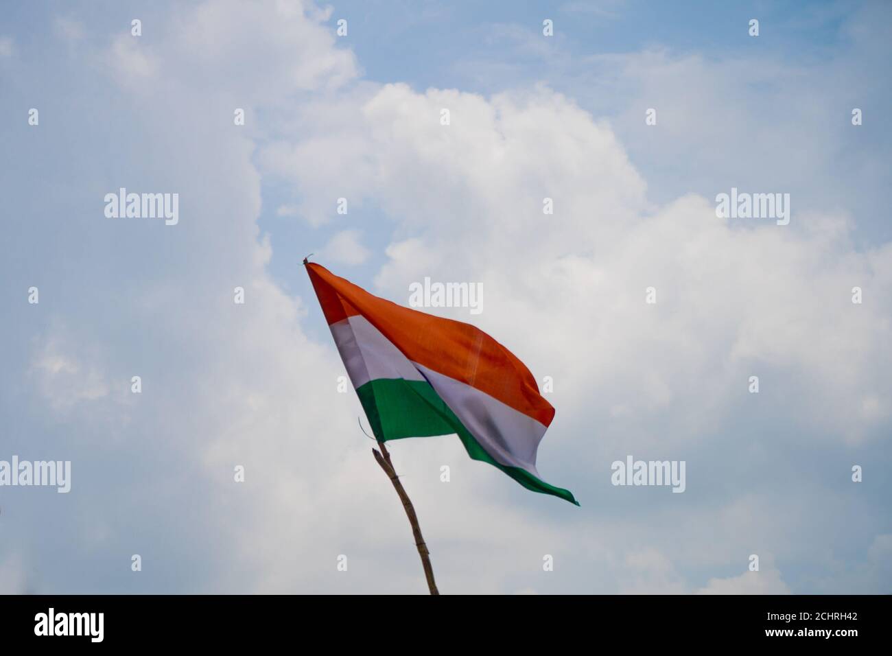 Indian tricolor flag mounted on a makeshift stick shot against a cloudy ...