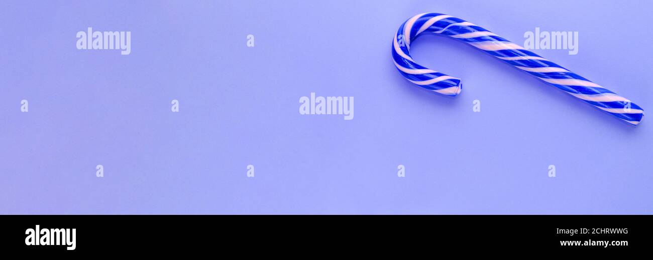 Single blue candy cane on blue background. Creative banner in minimal ...
