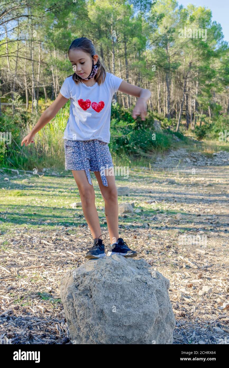 Pretty little girl climbed on a large rock in the Regajo reservoir ...
