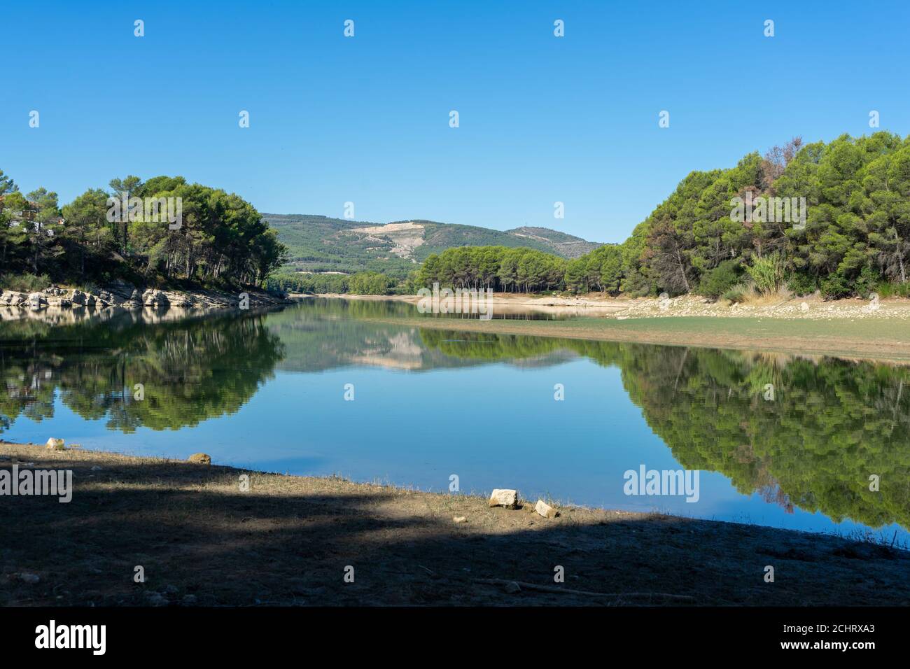 Reservoir landscape with nice reflections of the forest in the water on ...
