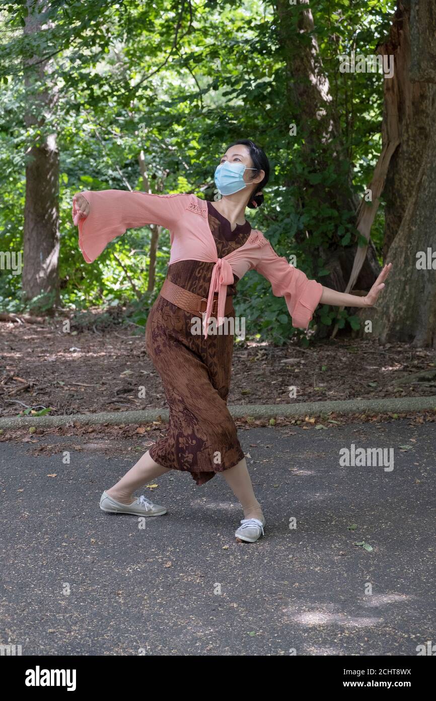 Surrounded by trees and foliage, a graceful Chinese American dancer ...