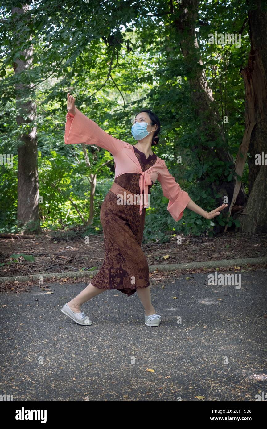 Surrounded by trees and foliage, an elegant Chinese American dancer ...