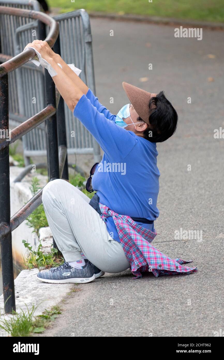 A middle aged Asian American woman stretches before her morning ...