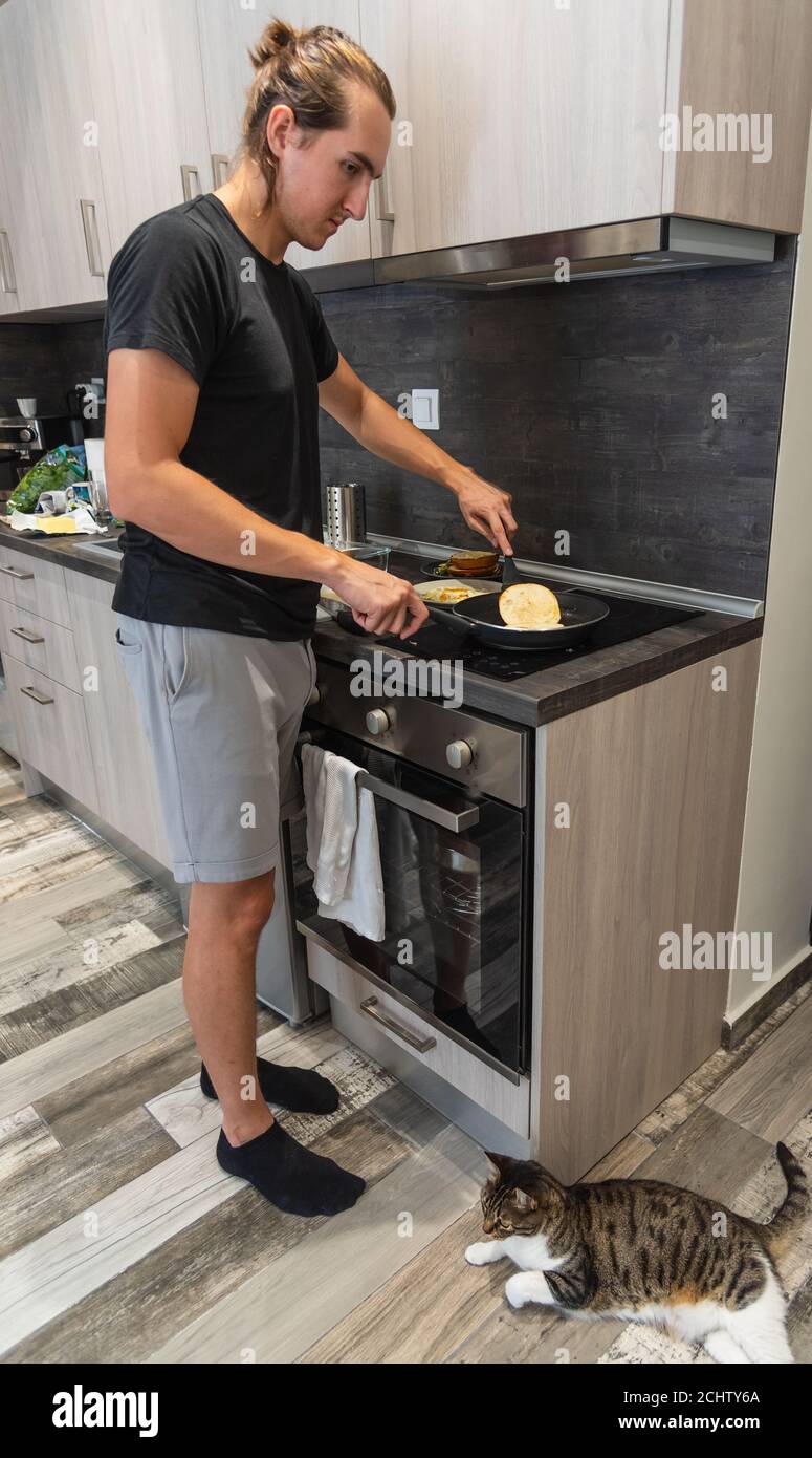 Young man toasting burger buns at pan in home Stock Photo - Alamy