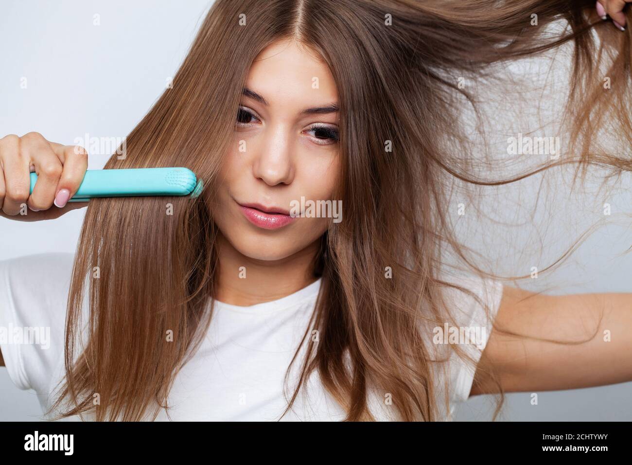 Woman With Beautiful Long Straight Hair Using Hair Straightener Stock ...