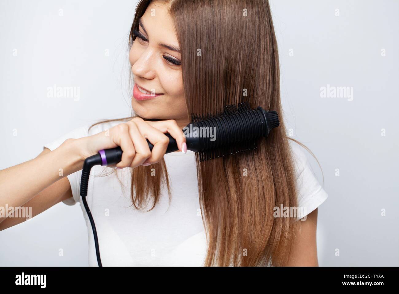 Woman With Beautiful Long Straight Hair Using Hair Straightener Stock ...