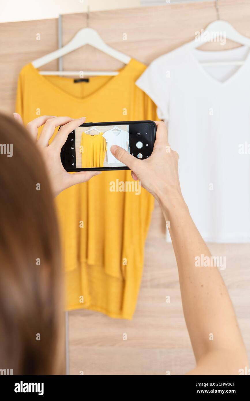 Woman taking picture of used clothes. Selling used clothes concept ...