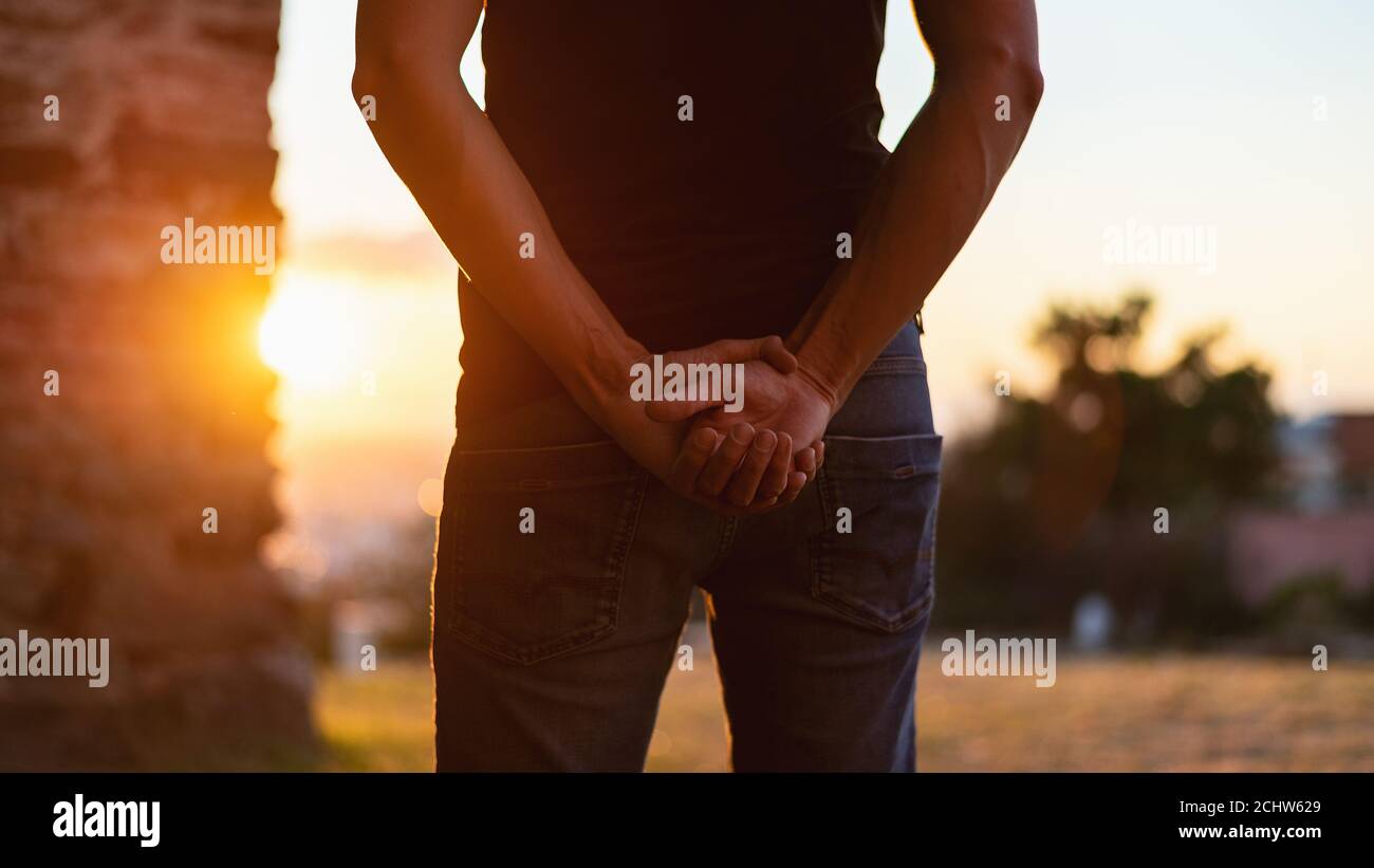 Man with clasped hands behind back Stock Photo - Alamy