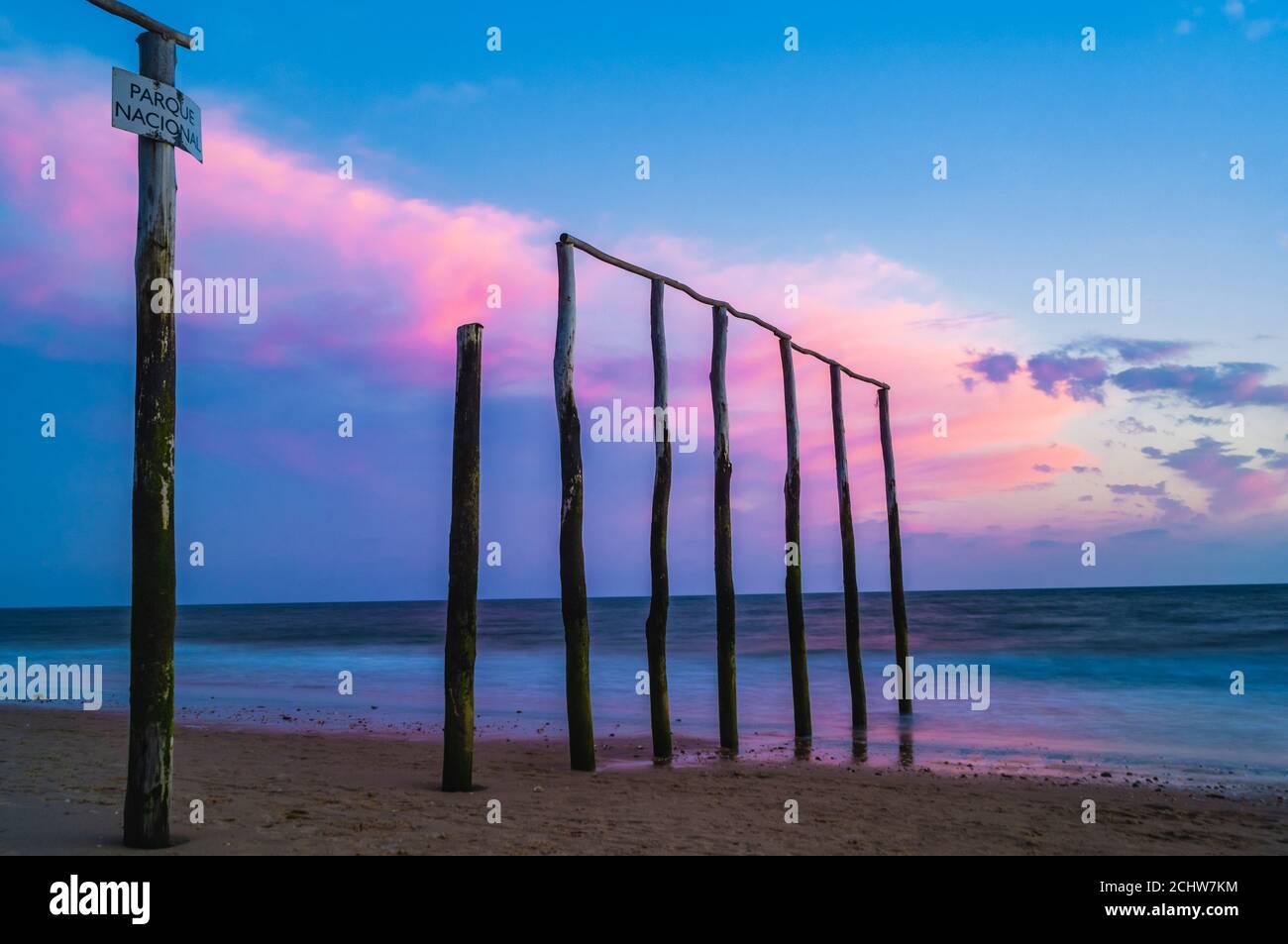 wooden poles on the beach at sunset glow Stock Photo - Alamy