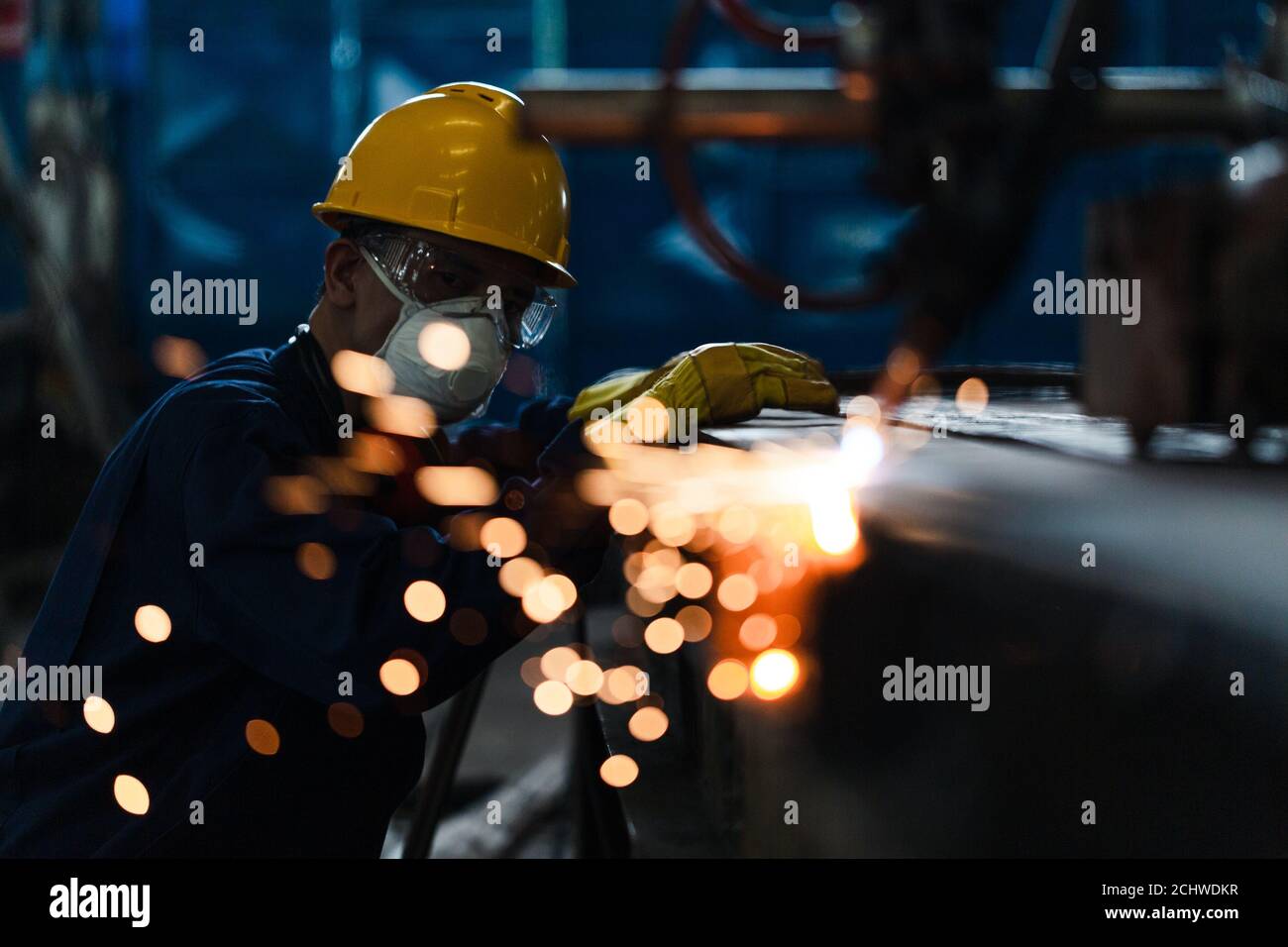 Asian worker using CNC plasma cutter Stock Photo - Alamy