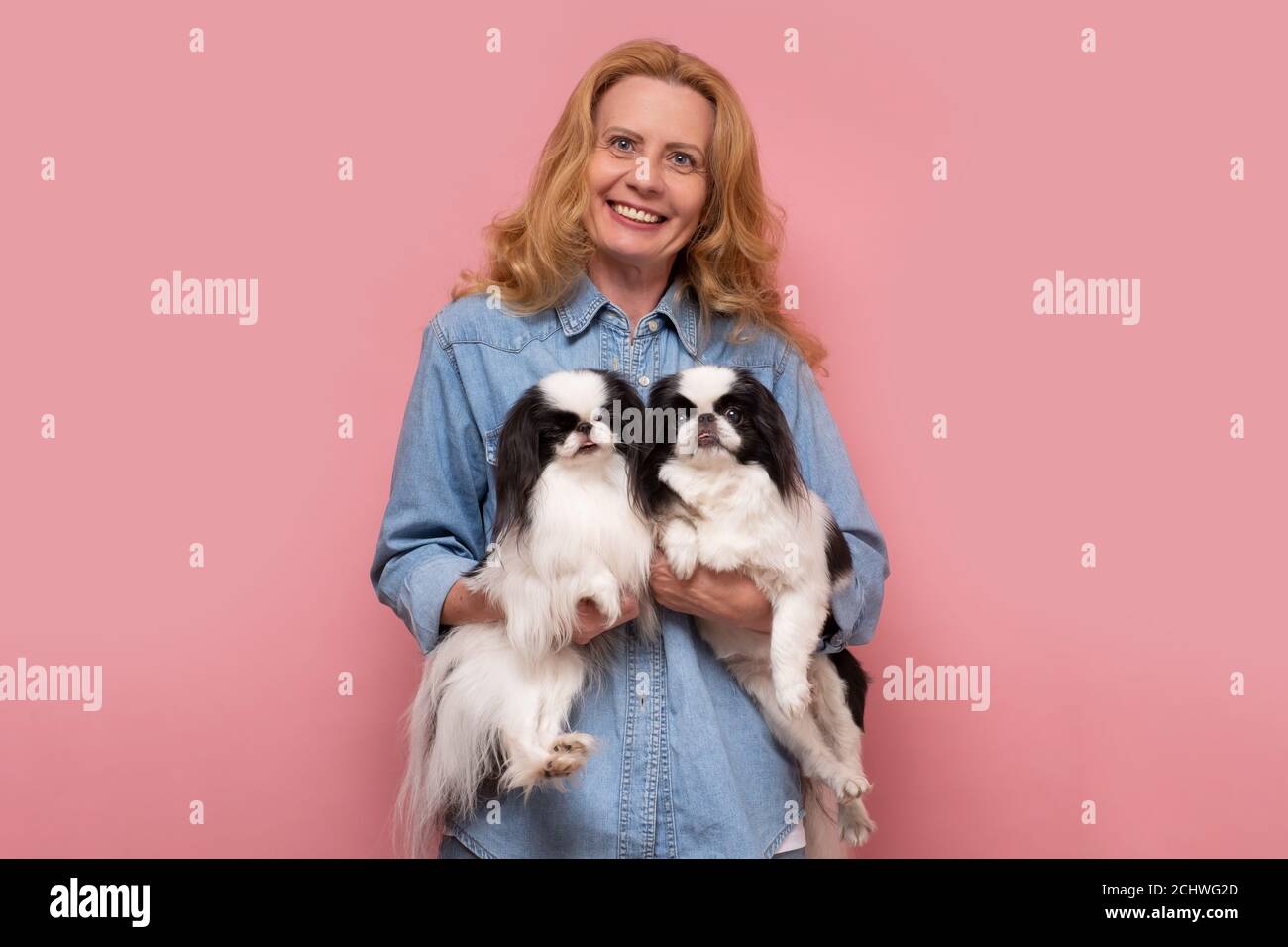Woman holding two dogs hi-res stock photography and images - Alamy