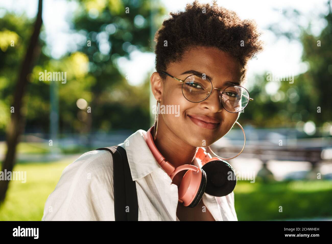 Photo of happy smiling african woman walking outdoors in park with ...