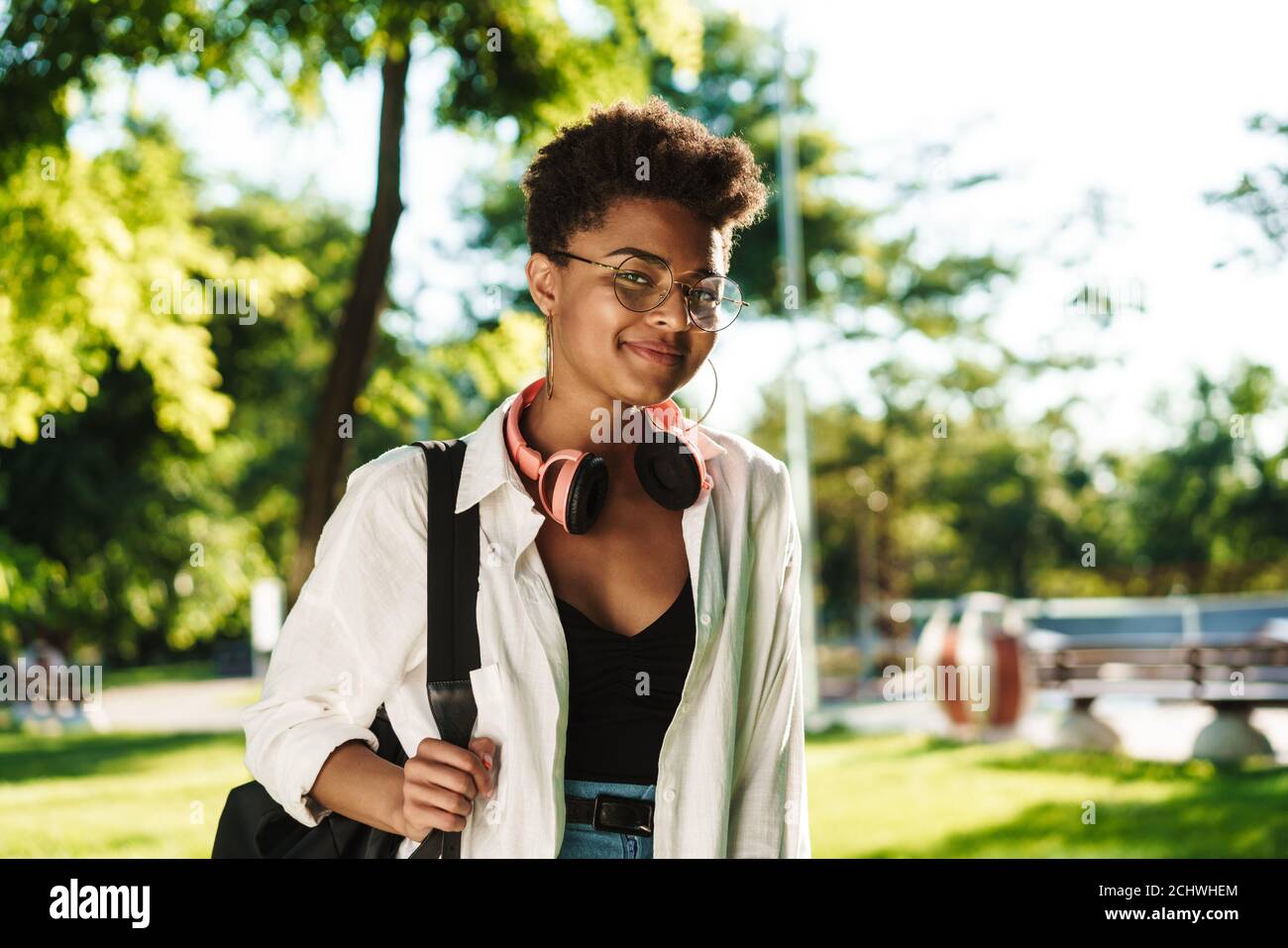Photo of happy smiling african woman walking outdoors in park with ...