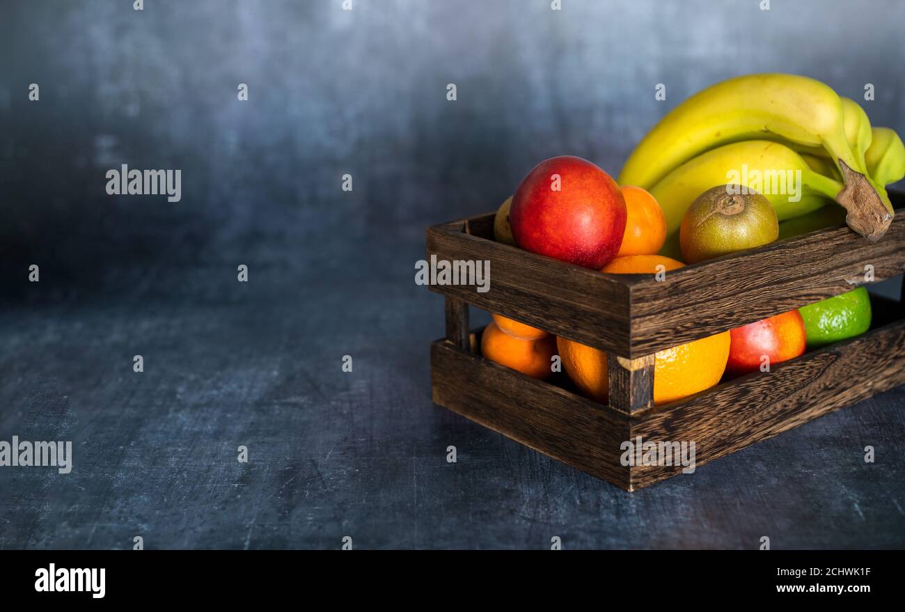 Wooden fruit box with banana, oranges, kiwi, peach, apricot on soft ...