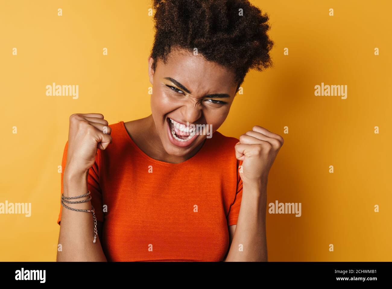 Image of excited african american woman screaming and making winner ...