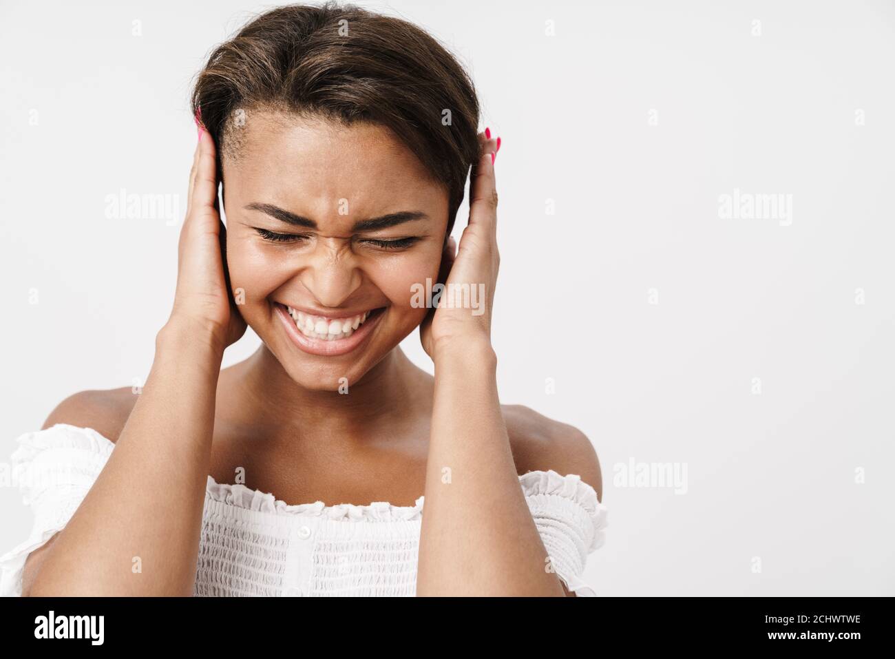 Image of joyful african american woman laughing and covering her ears ...