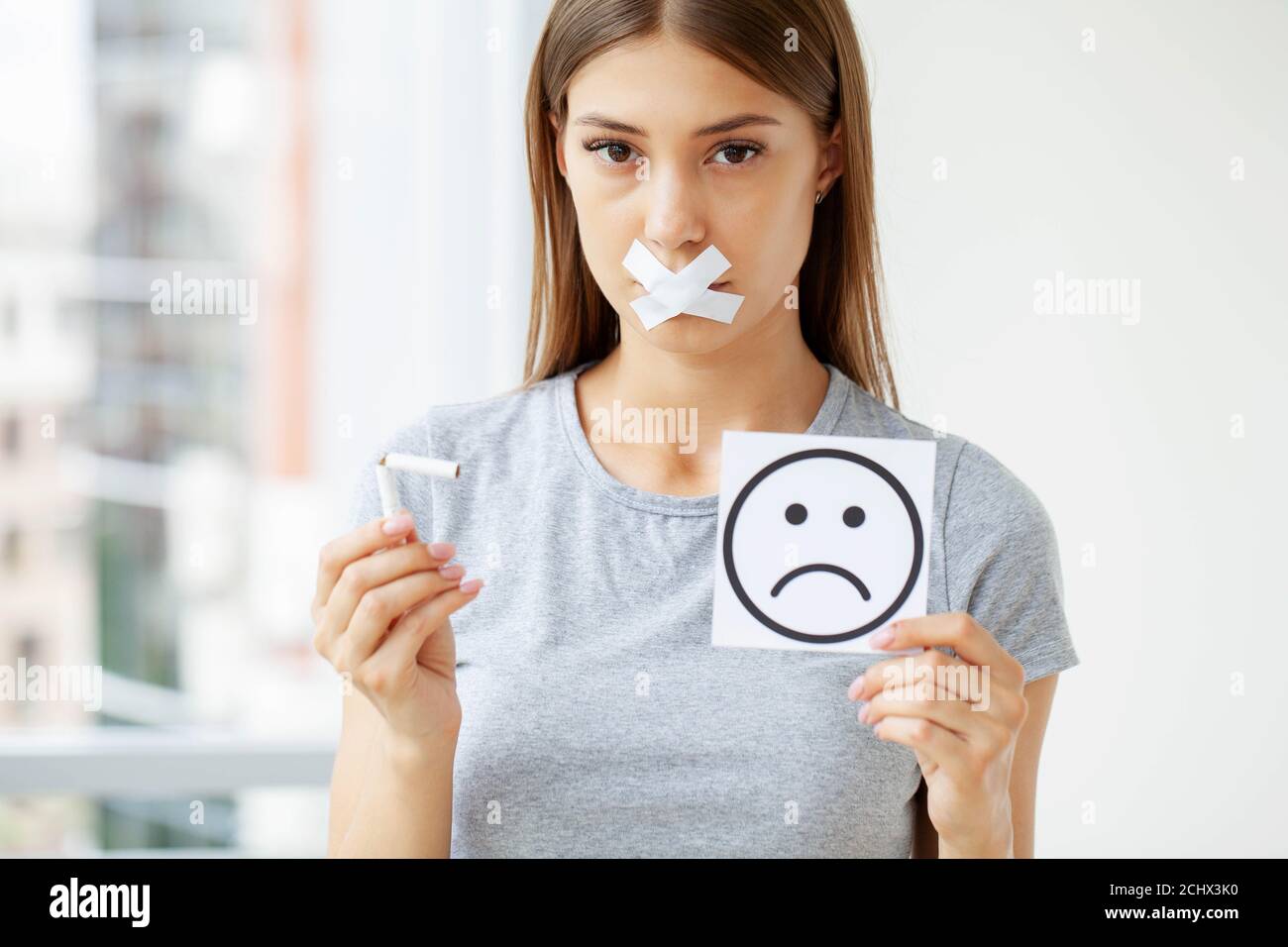 Stop smoking, woman holding a broken cigarette and a sad smile Stock ...