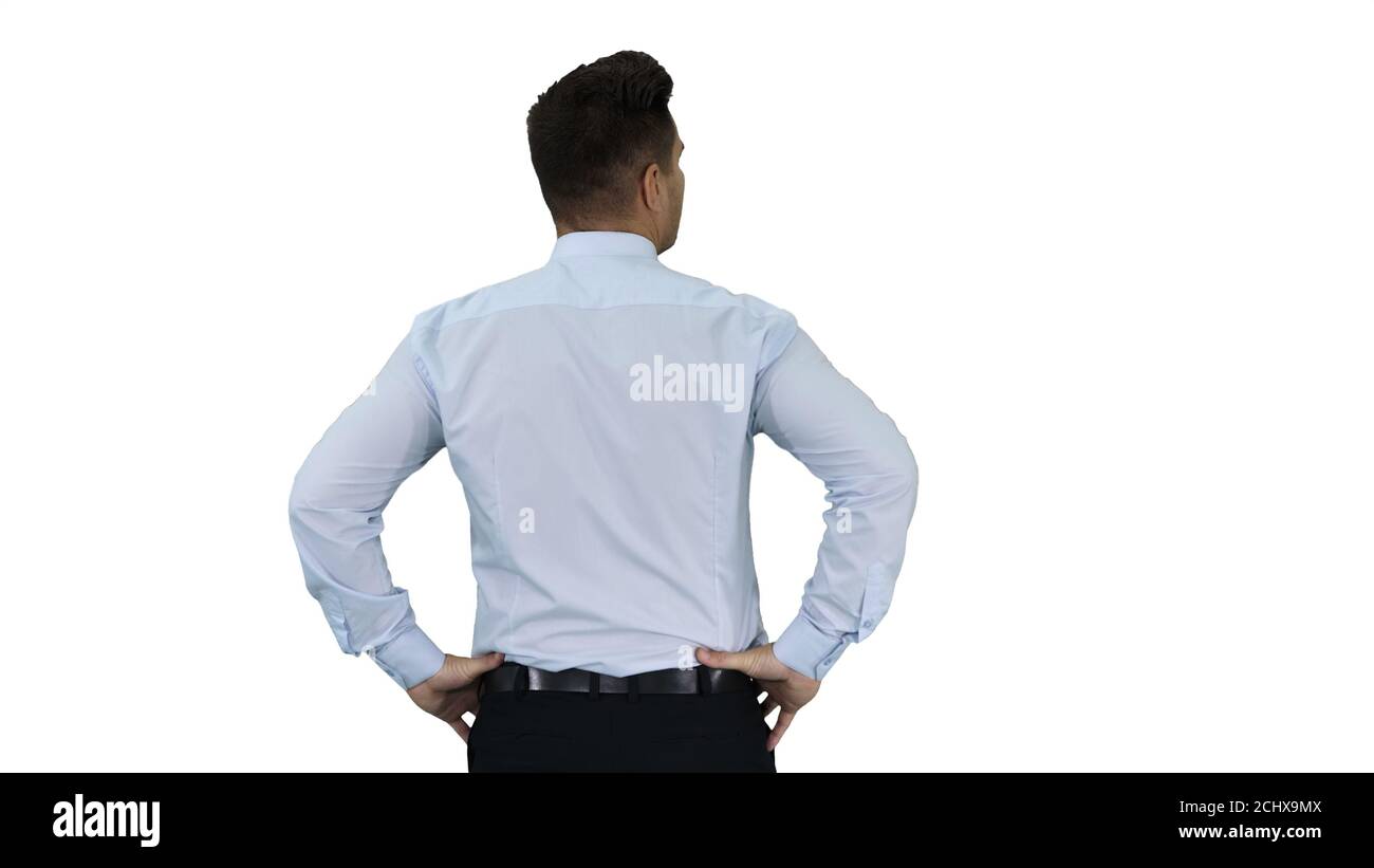 Man in blue shirt looking around checking something with hands on his ...