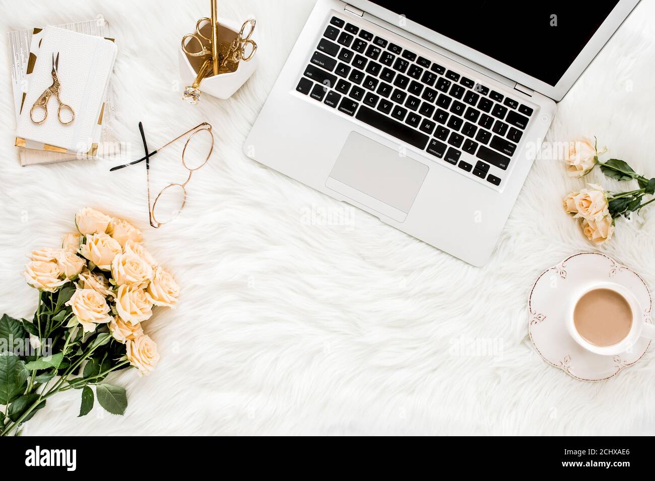Female workspace with laptop, roses flowers, golden accessories, diary ...
