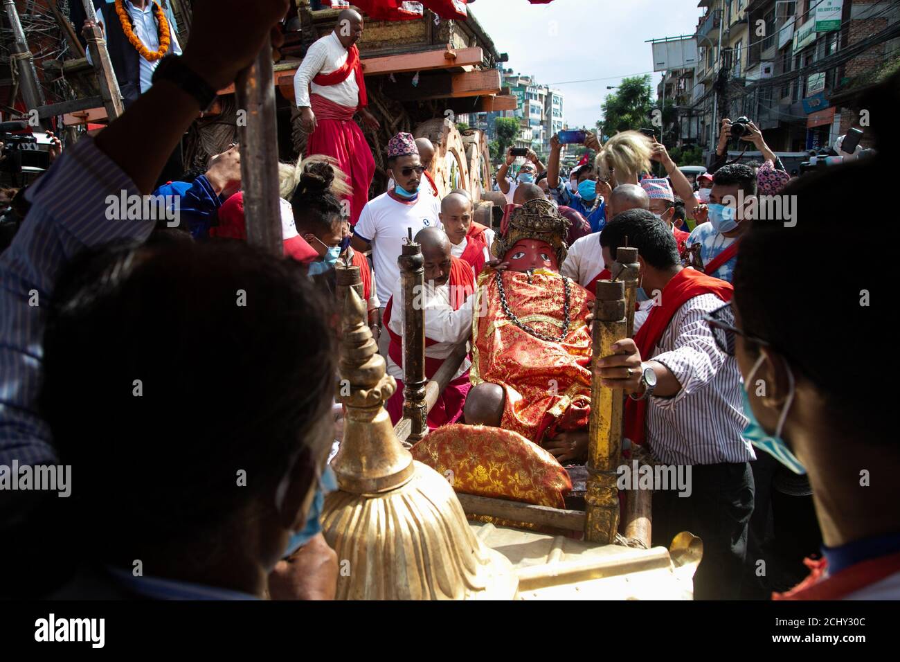 Priests take down the red idol Machhindranath from its chariot to the ...