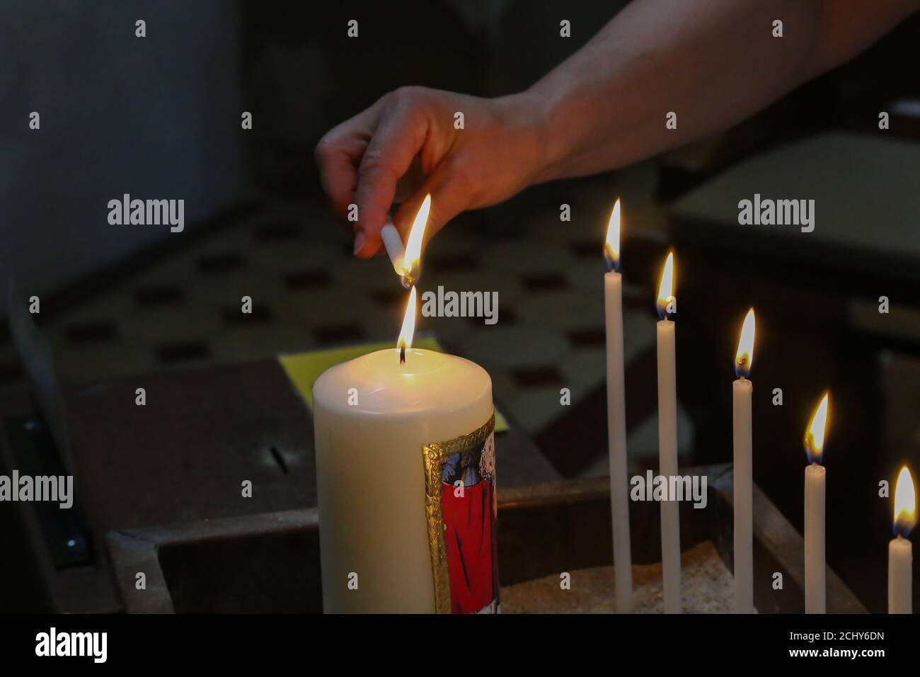Hand lighting a candle Stock Photo - Alamy
