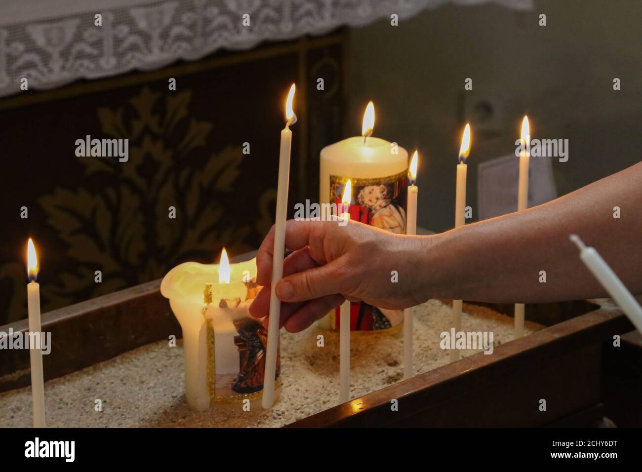 Hand lighting a candle Stock Photo - Alamy